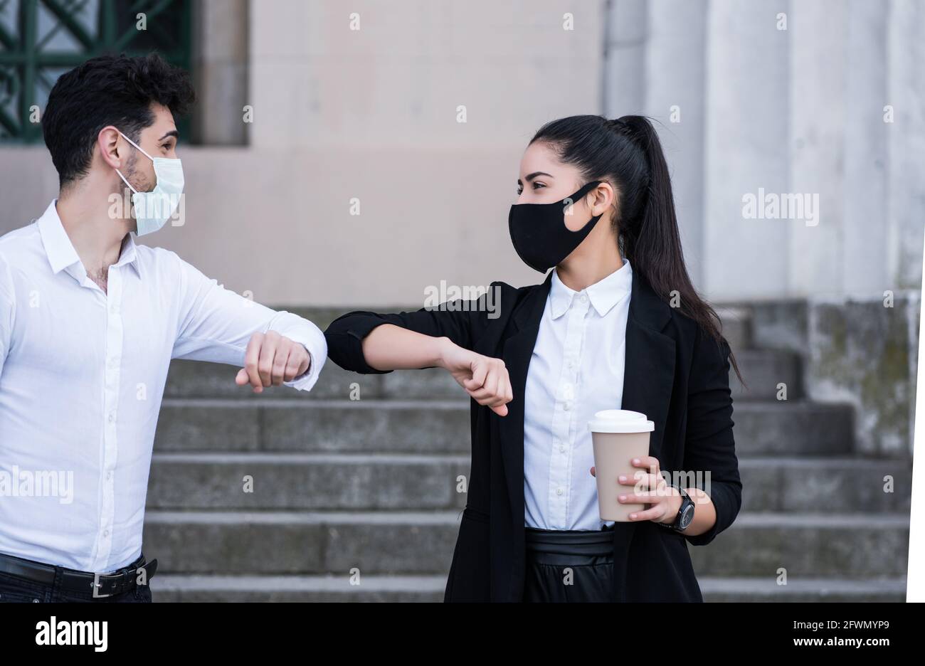 Business people bumping elbows for greeting each other Stock Photo - Alamy