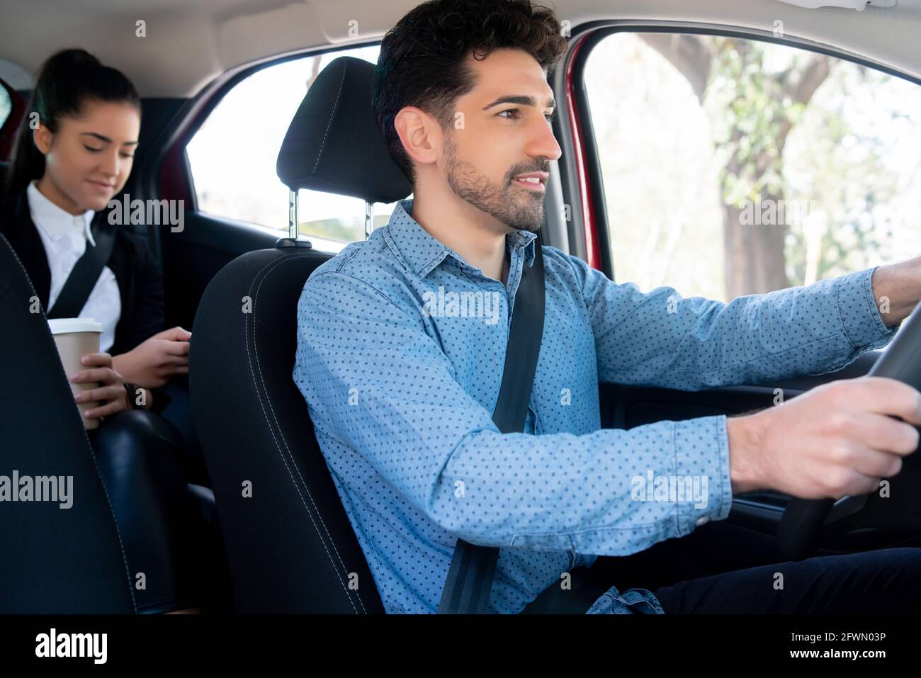 Taxi driver with passenger at back seat Stock Photo - Alamy