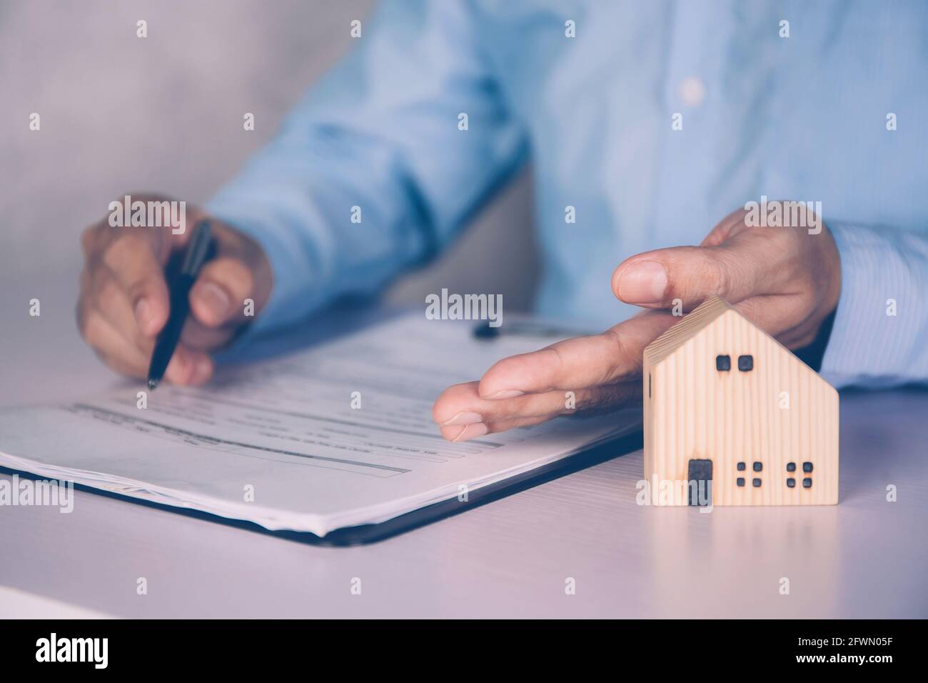 Real estate agent holding home and signing contract about agreement of ...