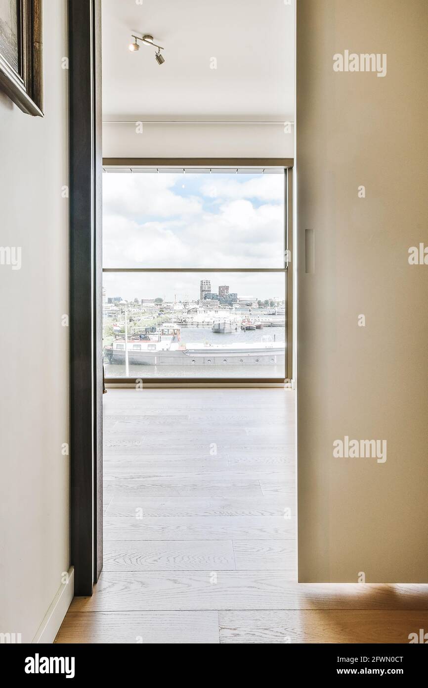 Perspective view through doorway of spacious room with large window ...