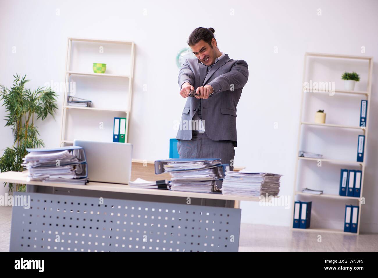 Male employee angry with excessive work holding firearm weapon Stock ...