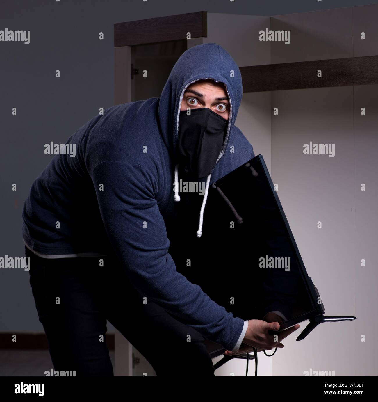 The burglar thief stealing tv from apartment house Stock Photo - Alamy