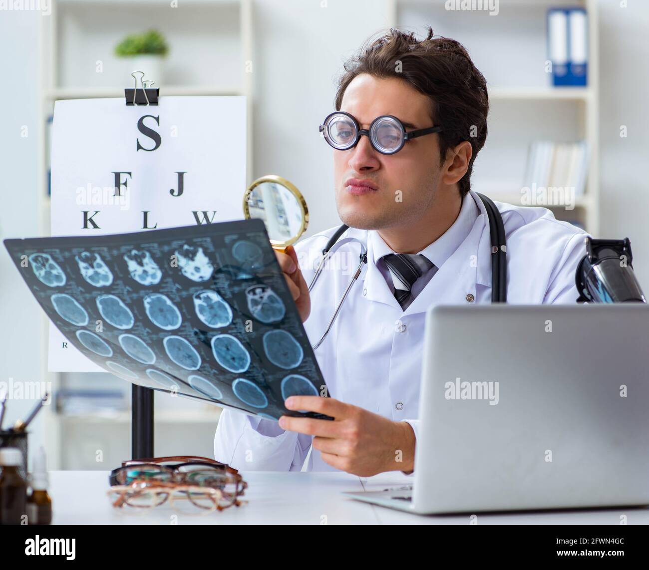 The funny eye doctor in humourous medical concept Stock Photo - Alamy