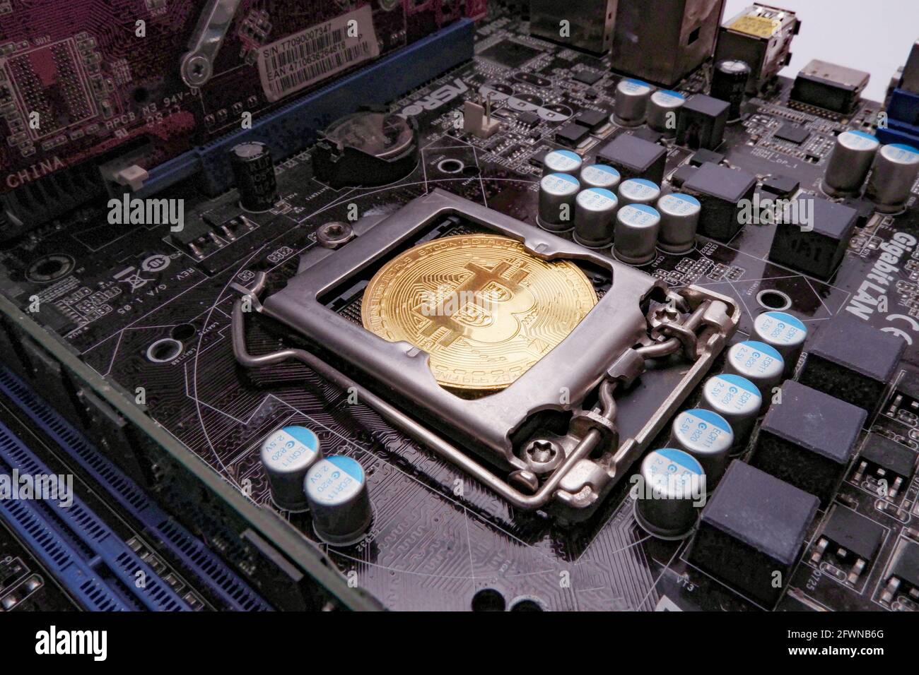 a bitcoin coin inserted into the motherboard slot for the computer ...