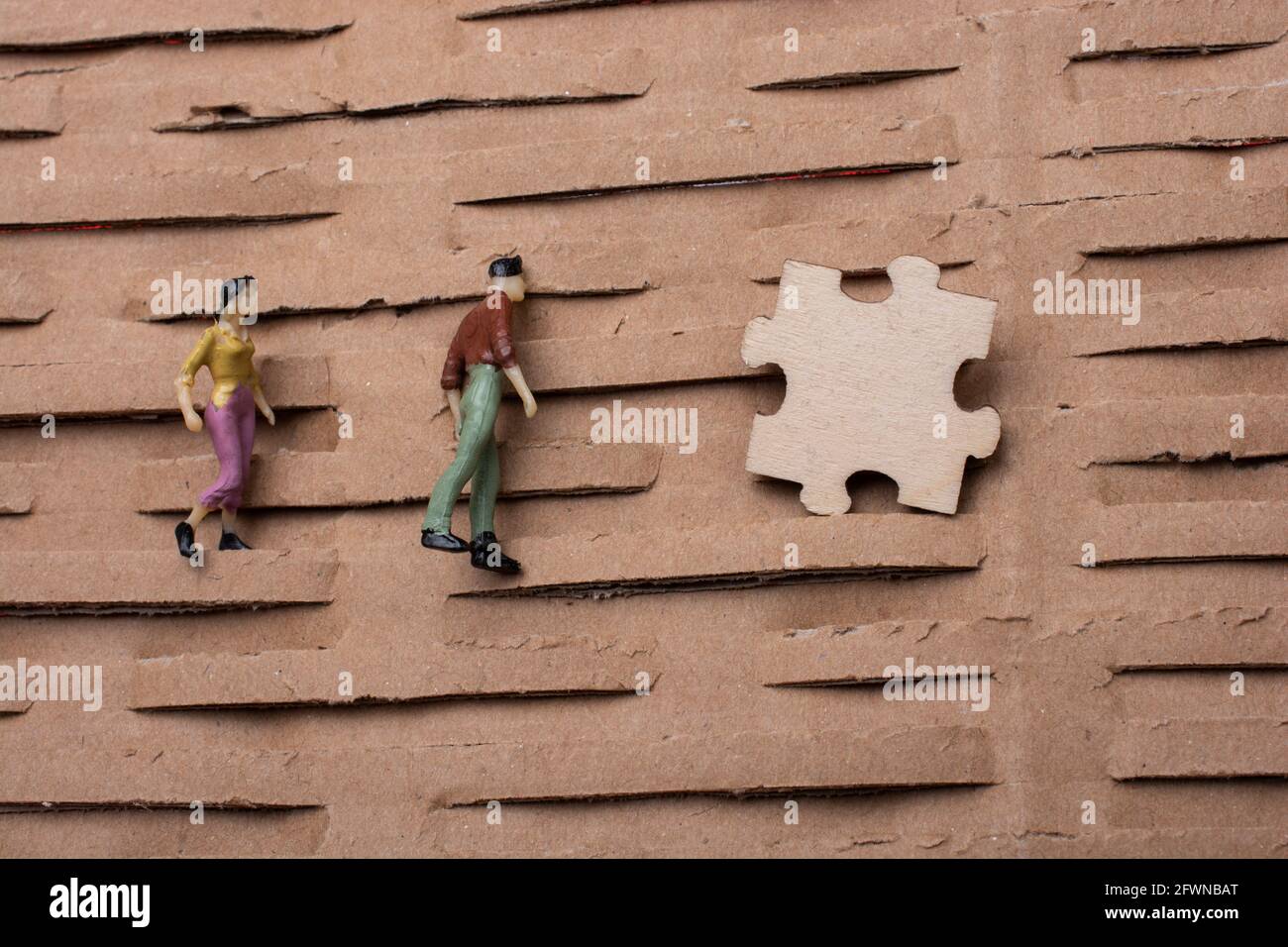 puzzle piece and tiny figurine of man and woman miniature model in view ...