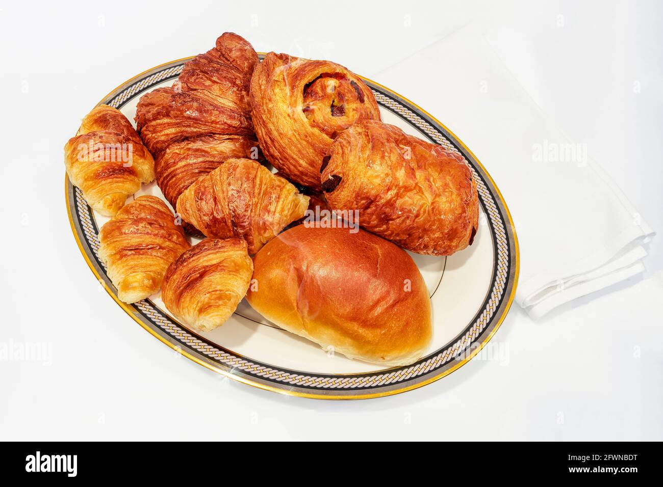 A varaity of sweet pastries on a large oval plate, white background ...