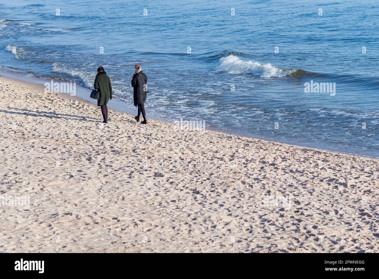 Two womans walking on the beach in spring.People walking on the beach ...
