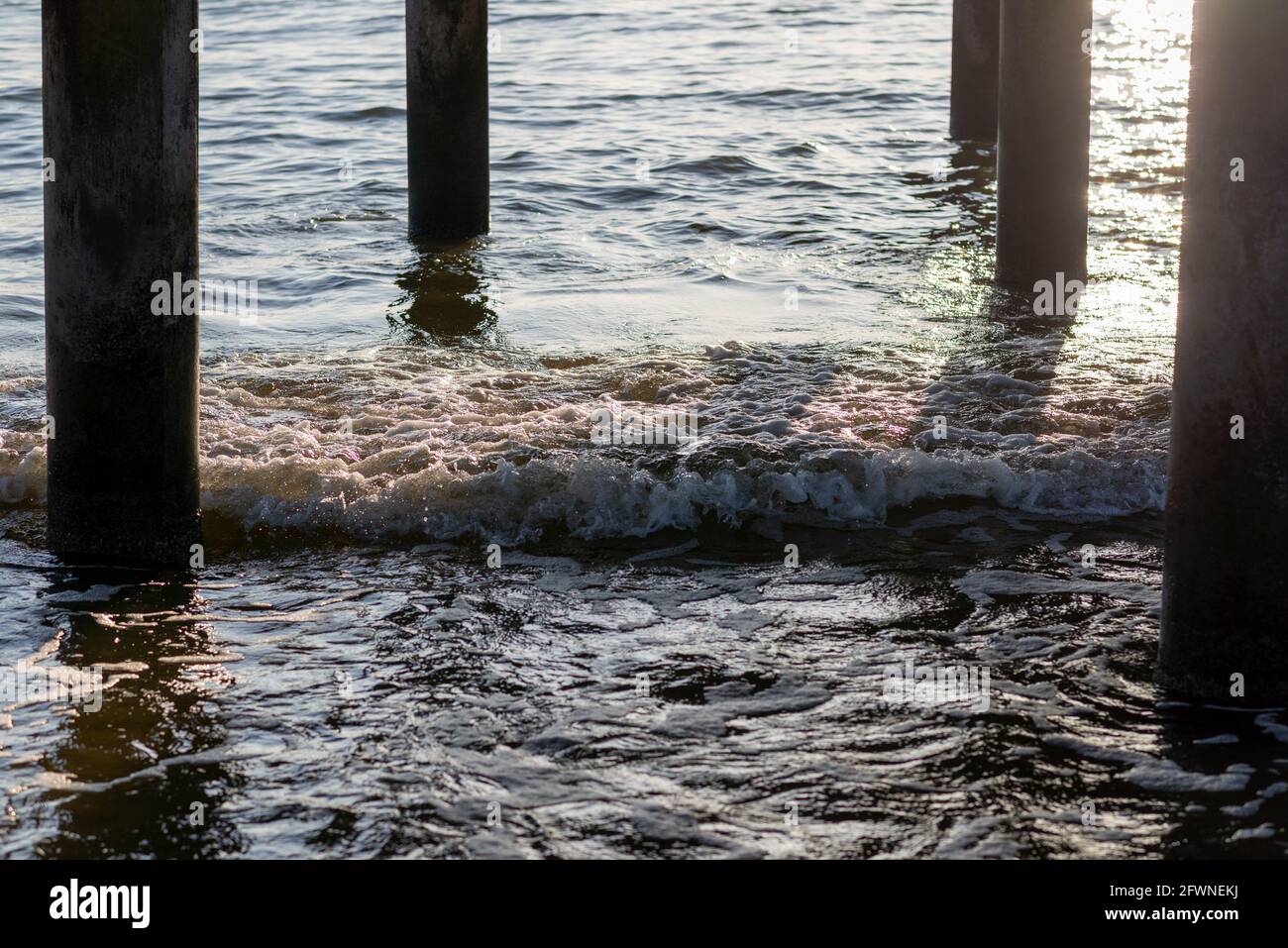 Columnar bridge piers at sunset.View under the bridge into sea with ...