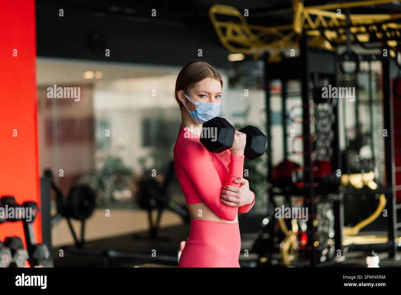 Woman wearing face mask exercise workout in gym during corona virus ...