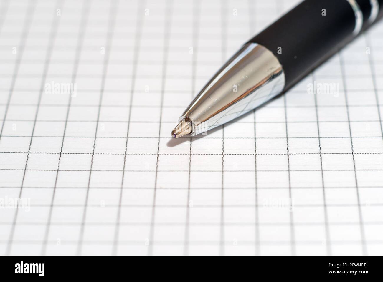 Ballpoint pen on the background of a sheet of checkered paper.Close up ...