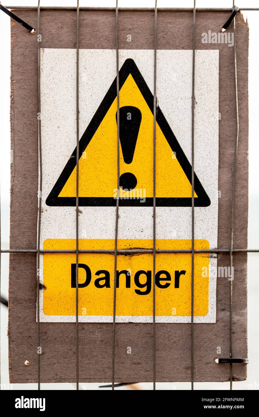 A yellow sign warning of danger Stock Photo - Alamy
