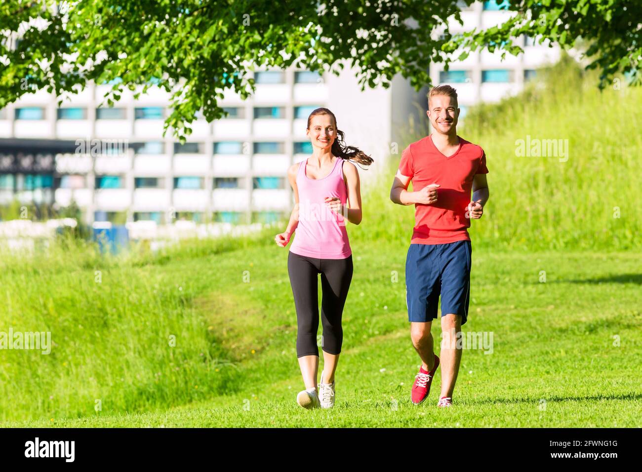 Fitness Friends running together through park Stock Photo - Alamy