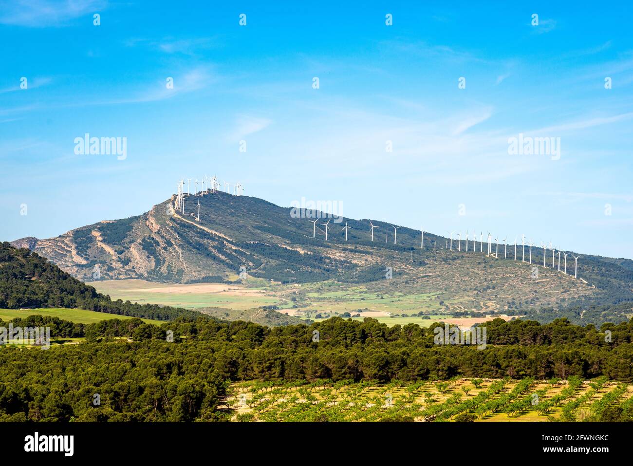 Wind Farm on a mountain crest. Blue sky with soft white clouds. Spanish ...