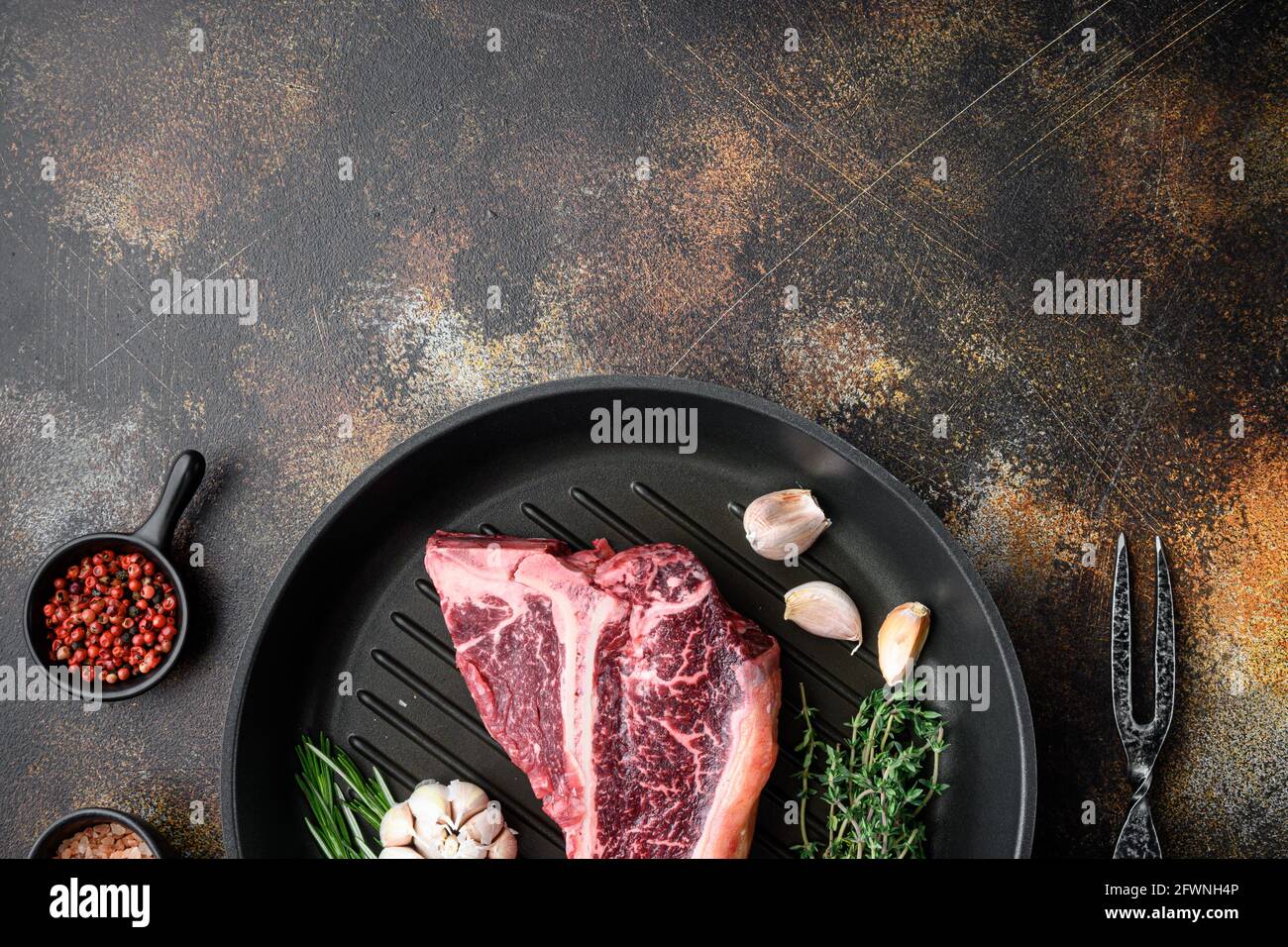 Raw t bone steak with ingredients set, on frying cast iron pan, on old ...