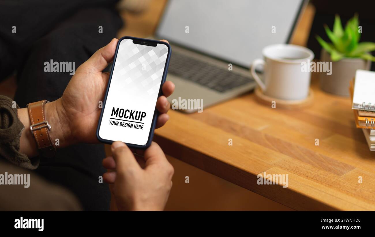 Close up view of male hands using smartphone while sitting at workplace ...