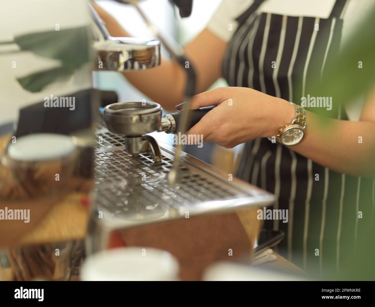 Side view of female barista hand working with coffee machine in cafe ...