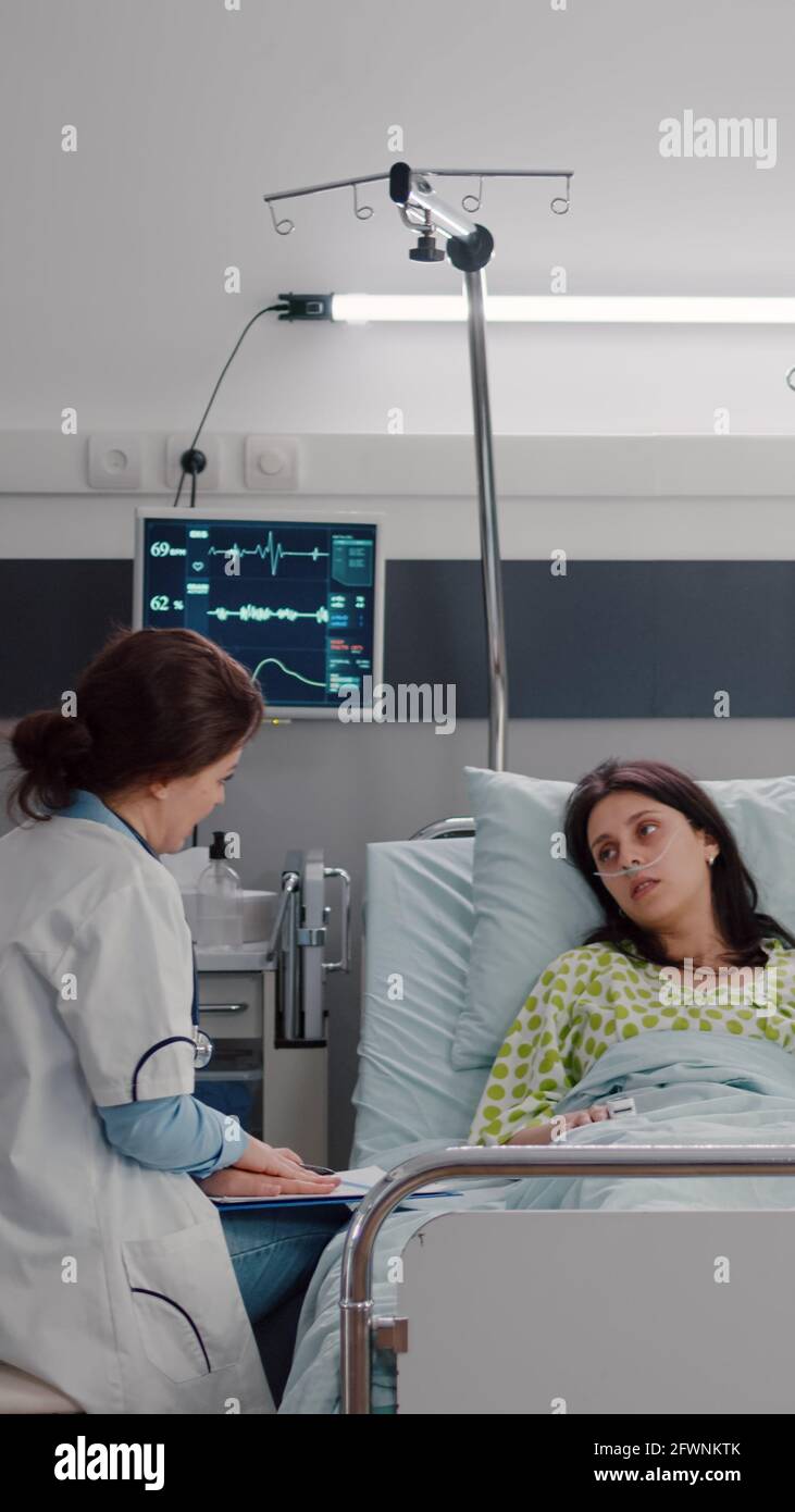 Specialist doctors monitoring sick woman discussing sickness treatment ...