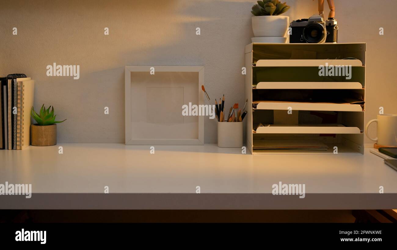 Workspace with stationery, office paper filing trays, decorations and ...