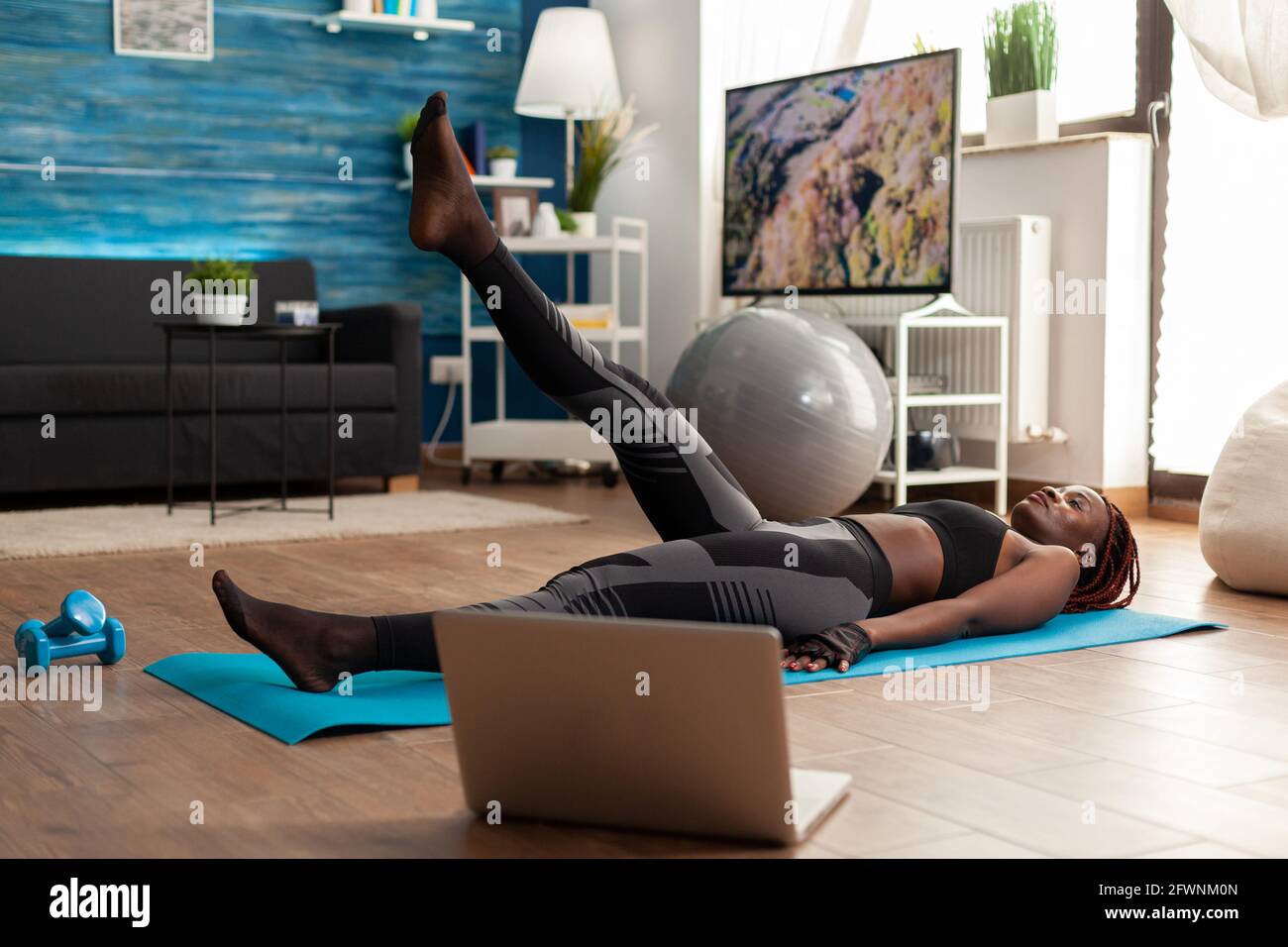 Active strong fit muscular fit woman on exercise mat doing scissors in ...