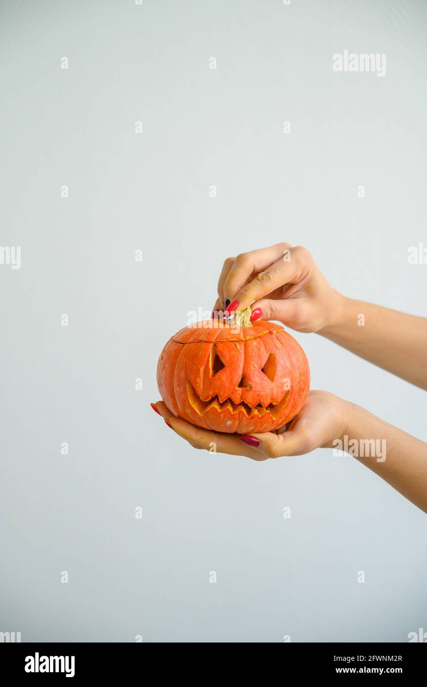 Female hands holding a pumpkin for Halloween. Close-up of a woman opens ...