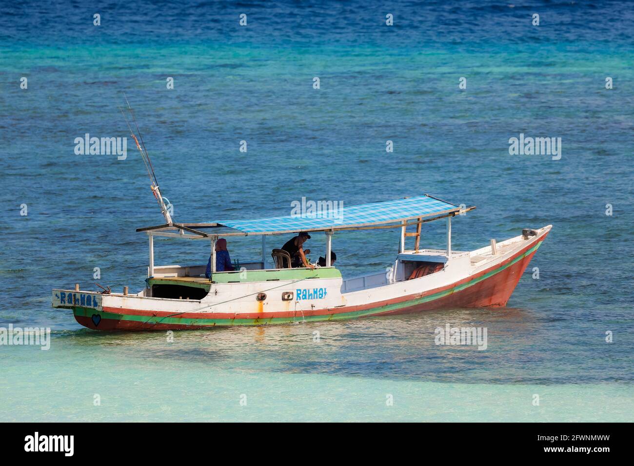 Traditional wooden ferry boat off beautiful white sand Bira Beach at ...