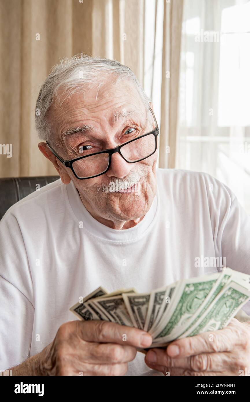 Silver Haired 88 Year Old Man With Glasses Happily Counts His Savings