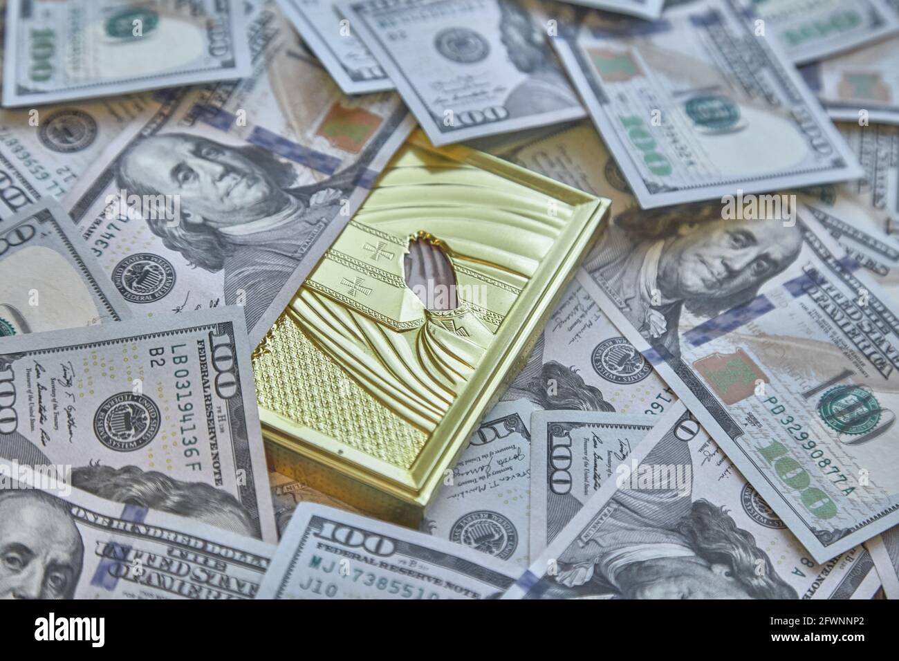 silhouette of a religious icon against a background of hundred-dollar ...