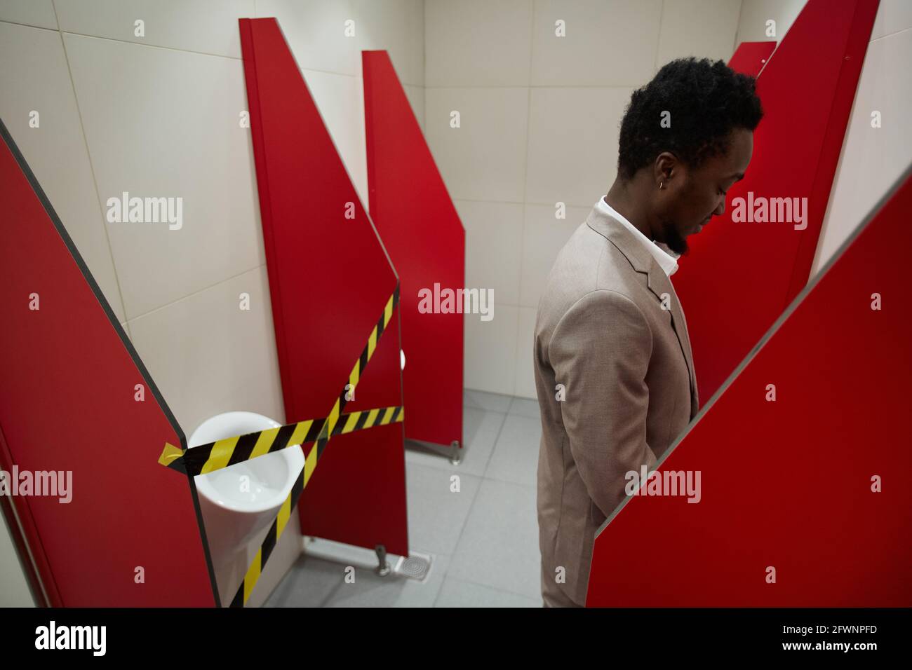 Graphic image of African-American businessman using public toilet with ...