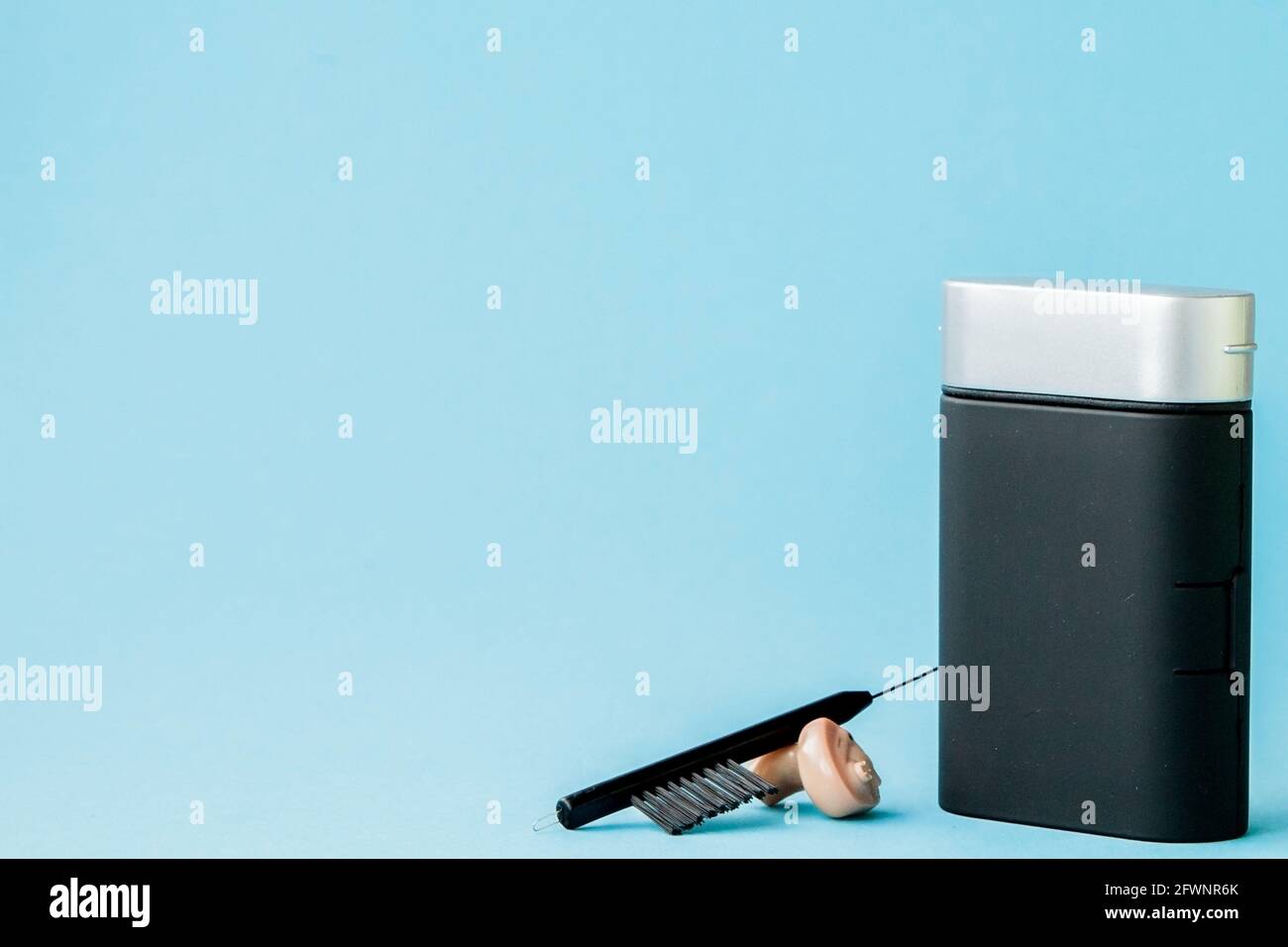 Box with hearing aid and accessories on color background. Medical ...