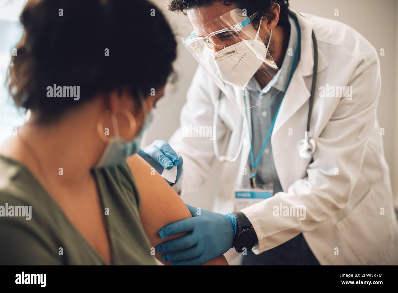 Healthcare professional giving vaccine to female at her home. Doctor ...