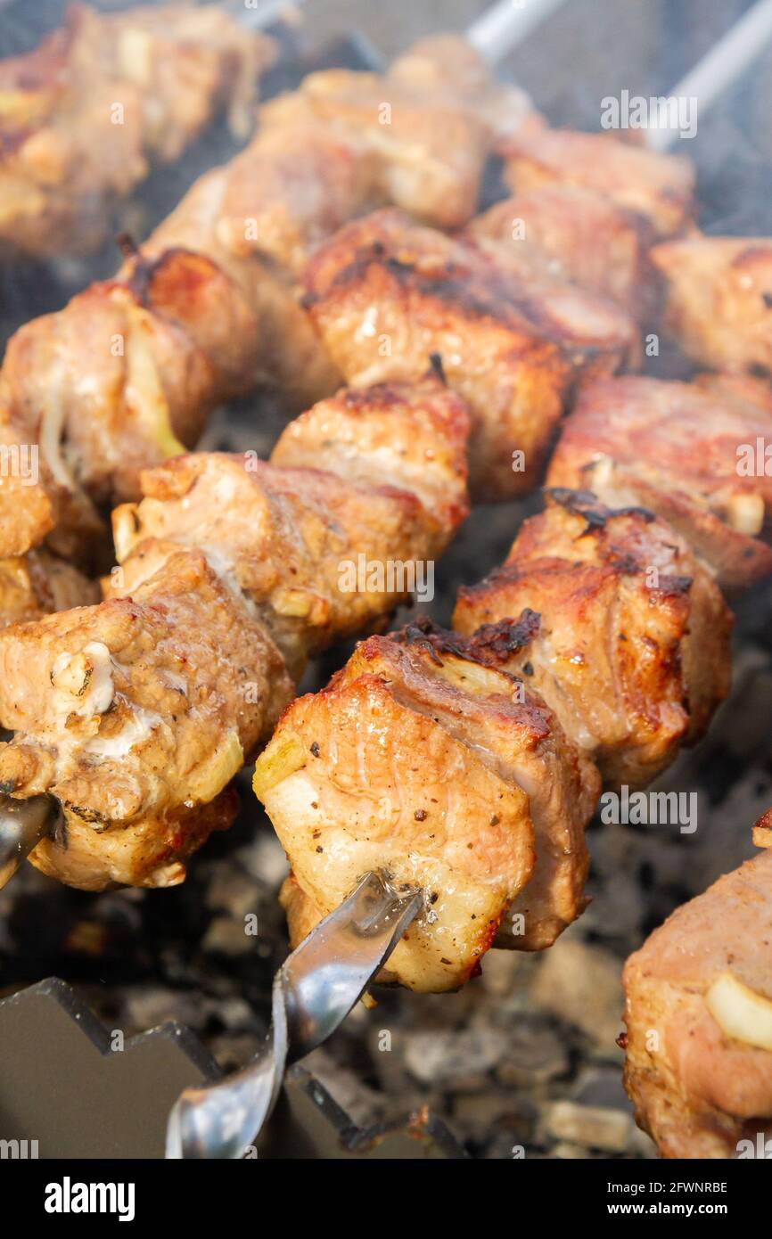 Shish Kebab made from pieces of pork is cooked on skewers on the grill ...