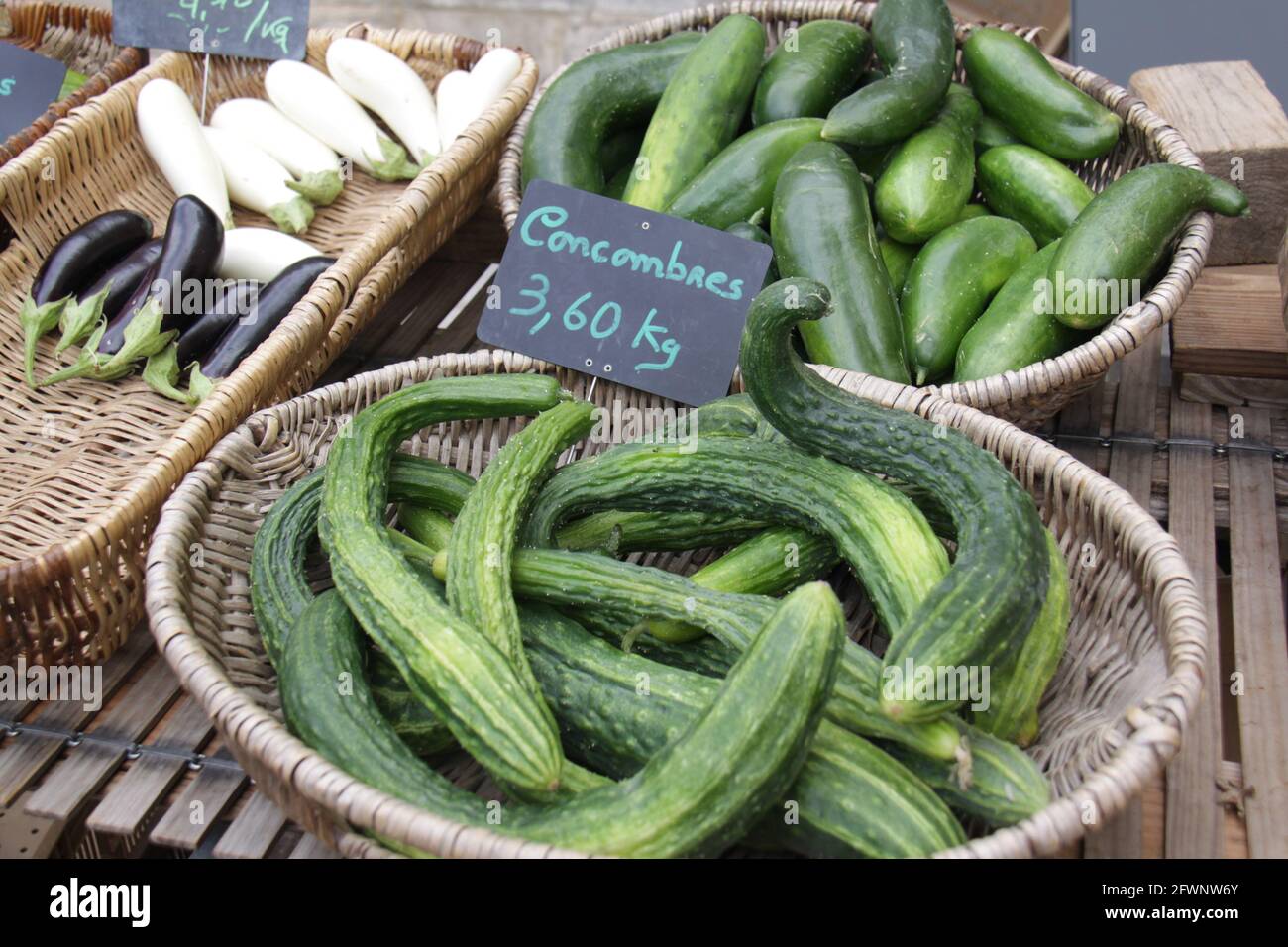 market stall display of oddly shaped cucumbers (text on sign reads ...
