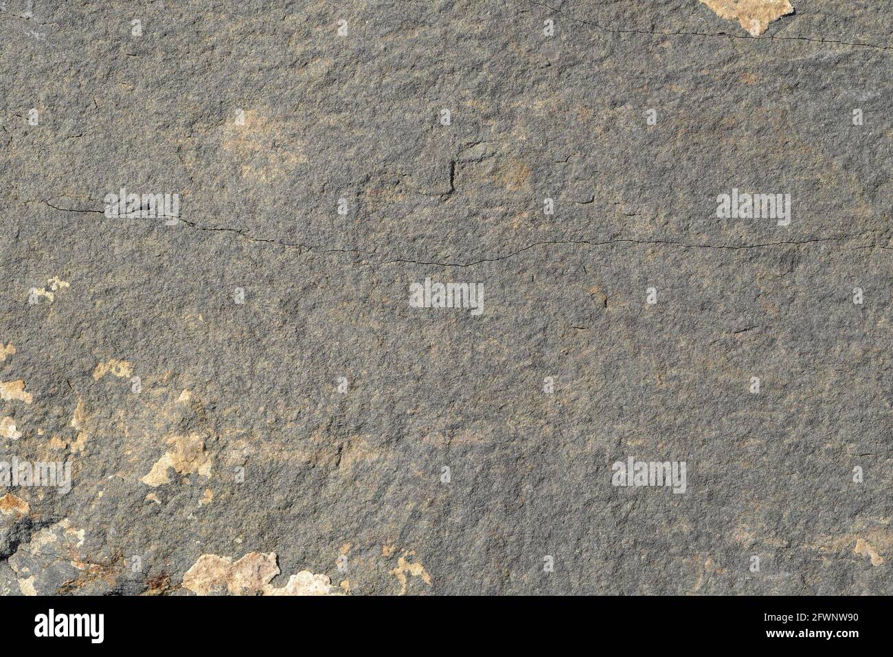 The texture of the surface of gray stone with cracks and light spots of ...