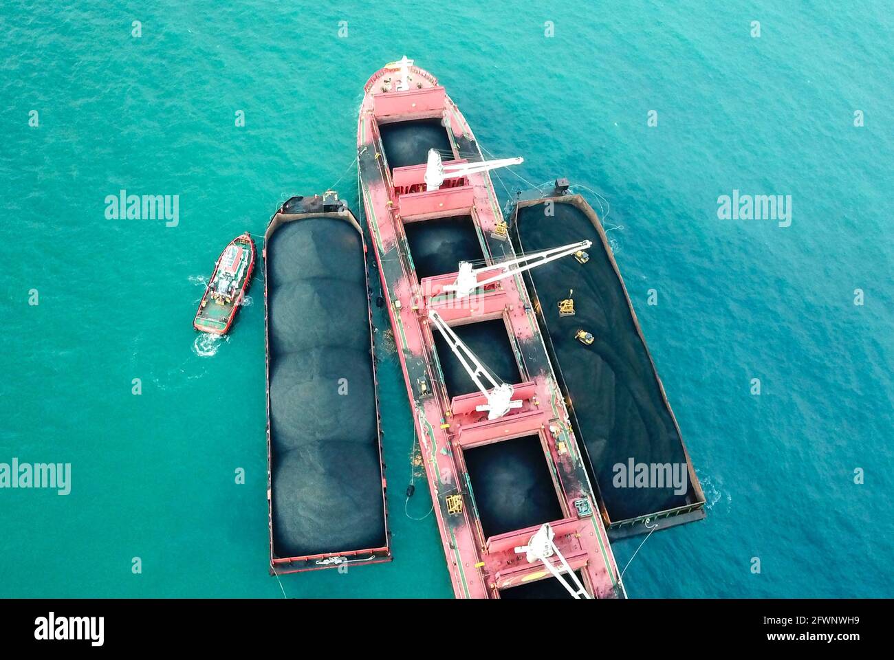 Transporting coal from the barge to the mother vessel aerial view Stock ...