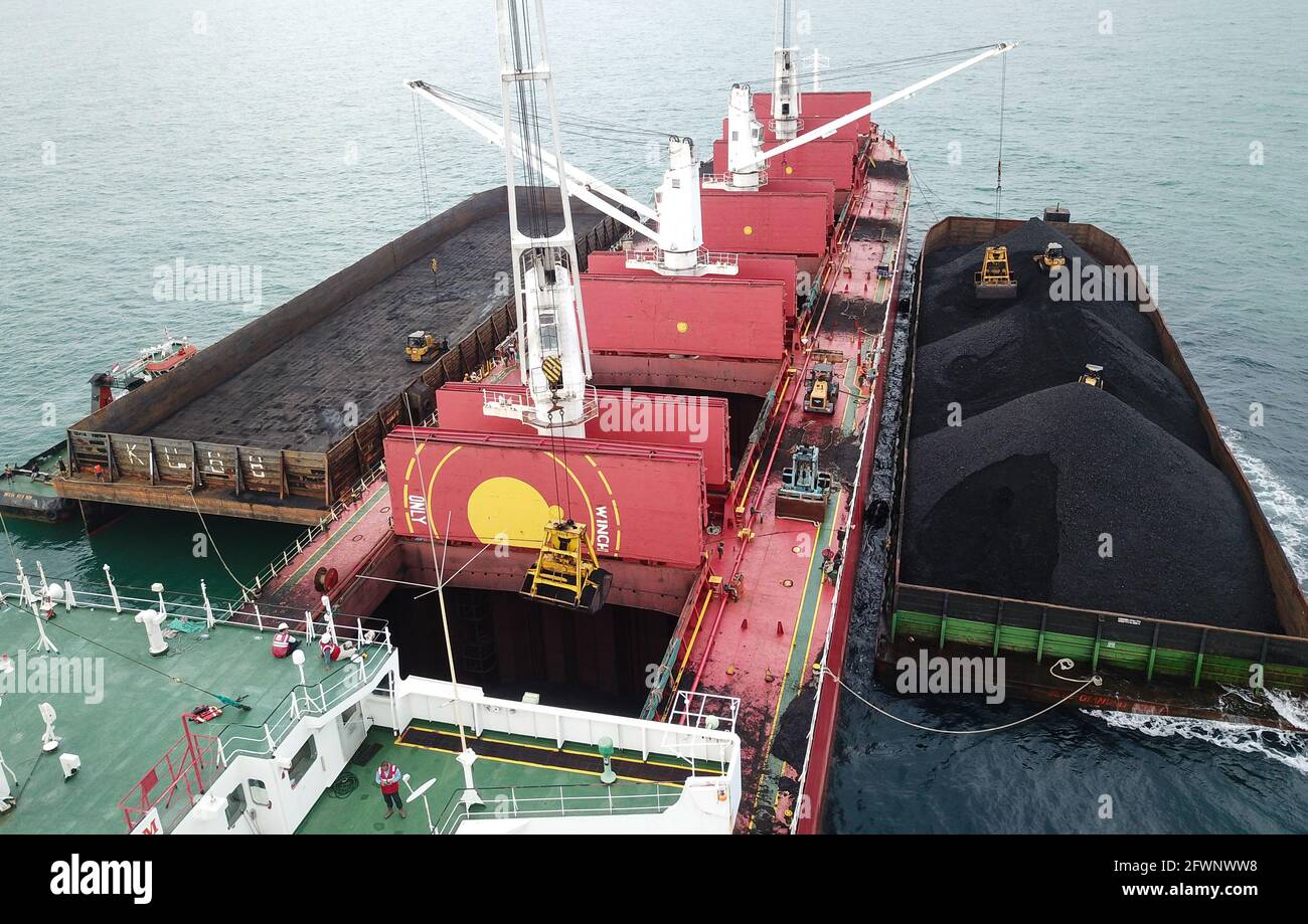 Transporting coal from the barge to the mother vessel aerial view Stock ...