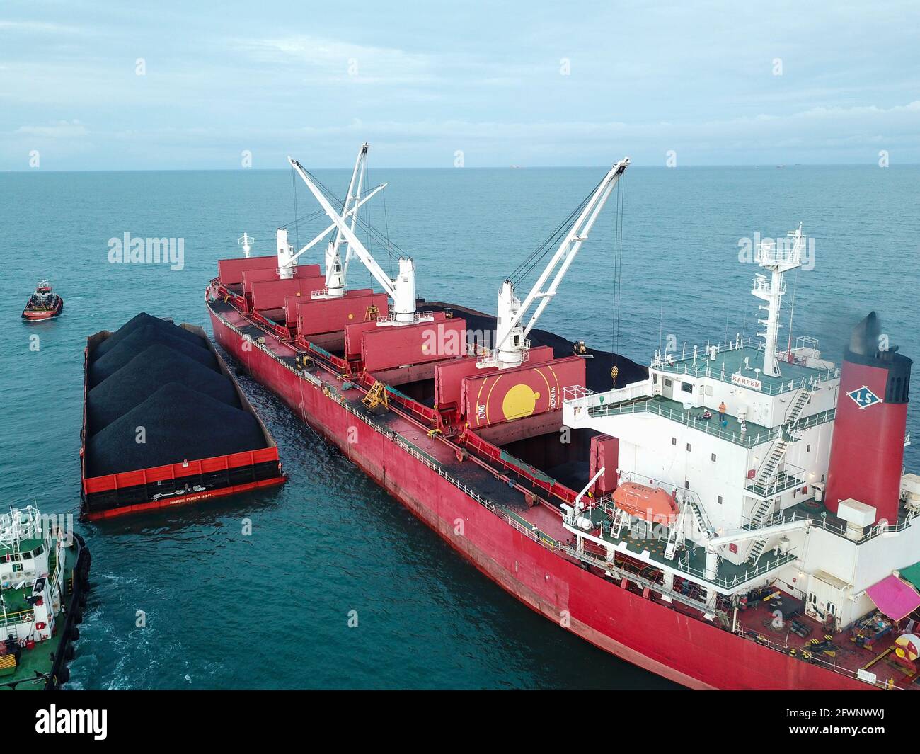 Transporting coal from the barge to the mother vessel aerial view Stock ...