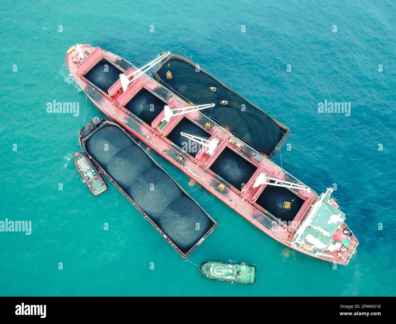 Transporting coal from the barge to the mother vessel aerial view Stock ...