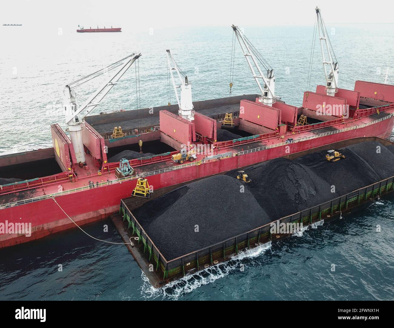 Transporting coal from the barge to the mother vessel aerial view Stock ...