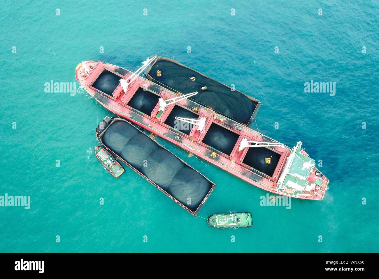 Transporting coal from the barge to the mother vessel aerial view Stock ...