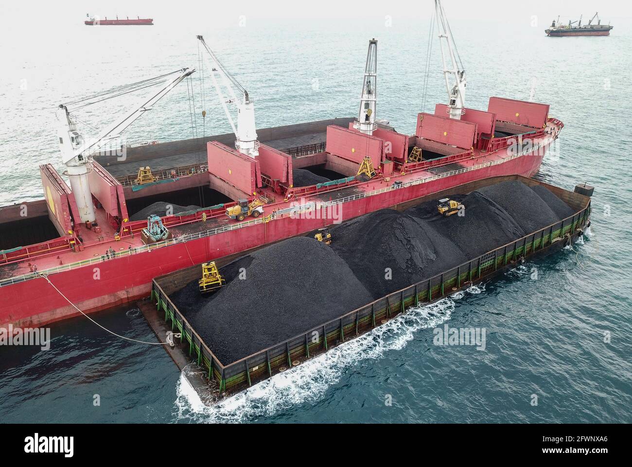 Transporting coal from the barge to the mother vessel aerial view Stock ...