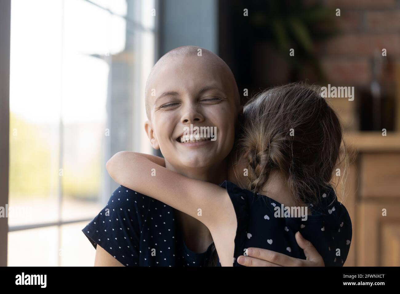Overjoyed young mother with cancer hugging daughter girl Stock Photo ...