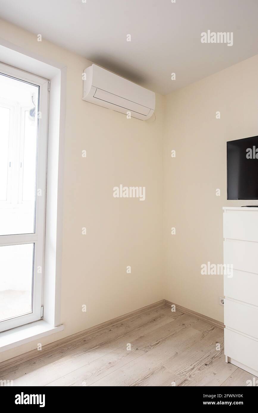 The air conditioner is installed in the corner of the real room next to ...