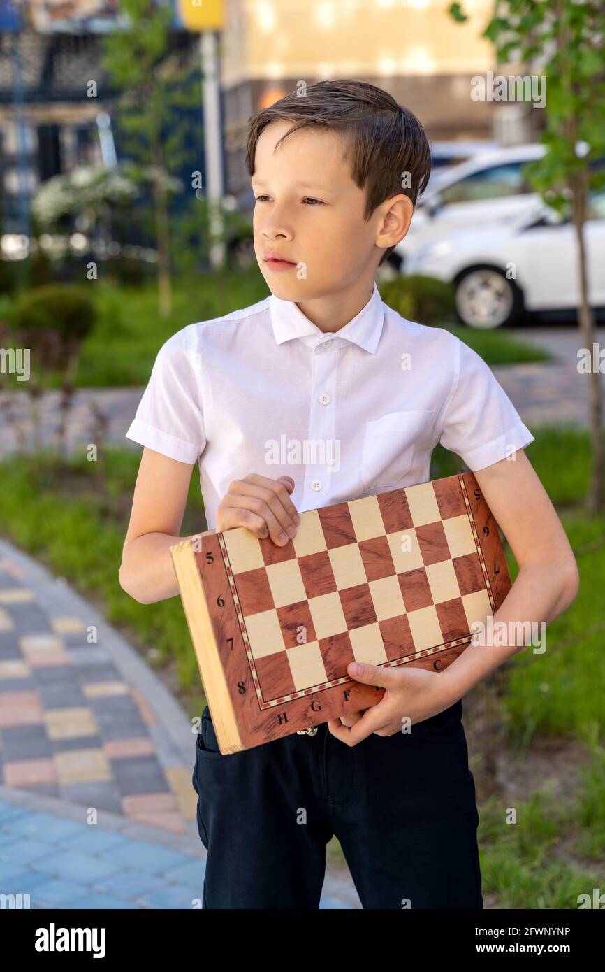 a handsome schoolboy in a white shirt with a chess board Stock Photo ...