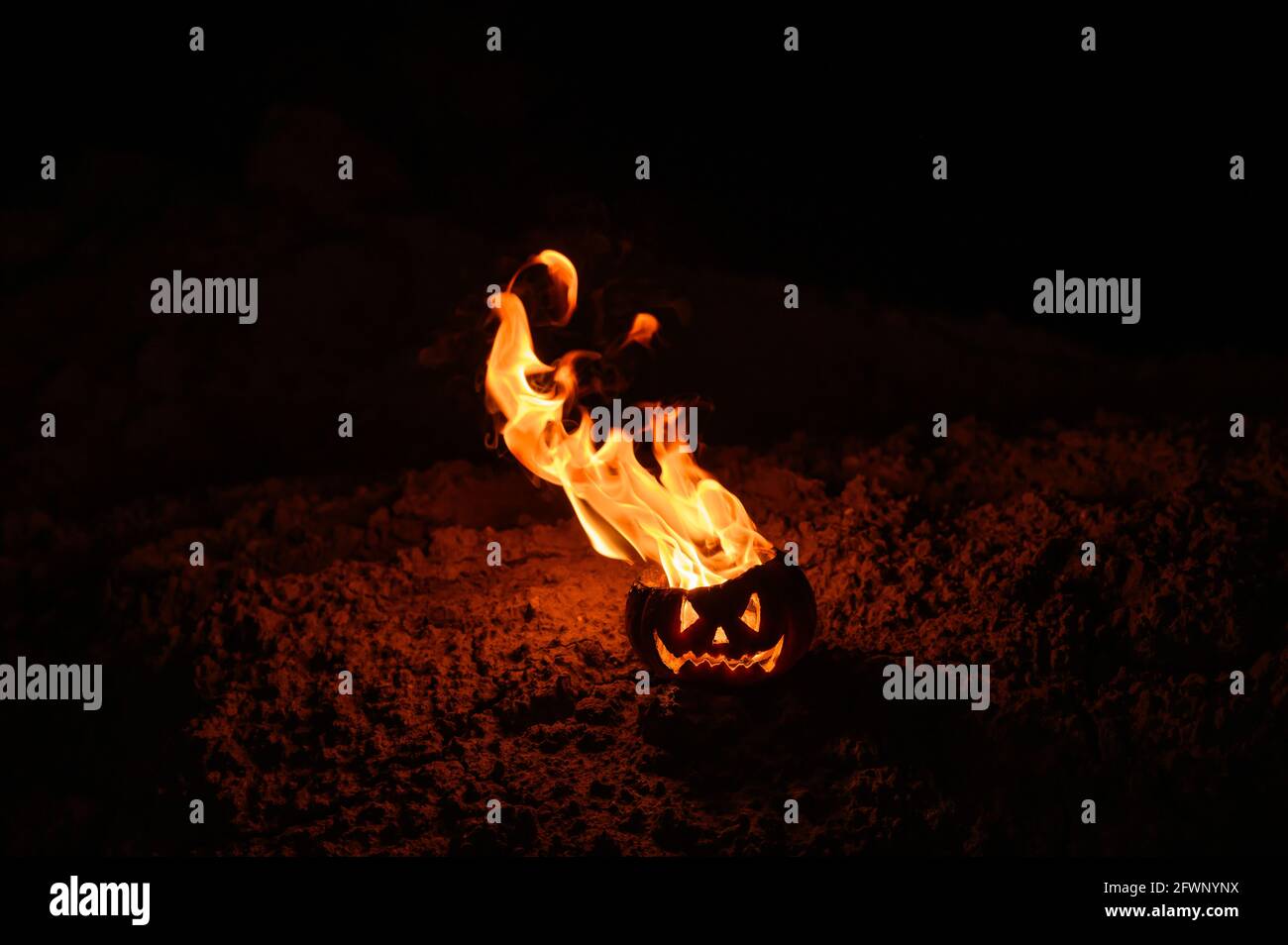 Tongues of flame in a pumpkin. jack-o-lantern on fire on a black ...