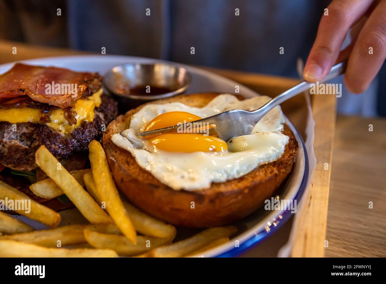 Close-up of a fried egg on a half burger in a plate with fries Stock ...