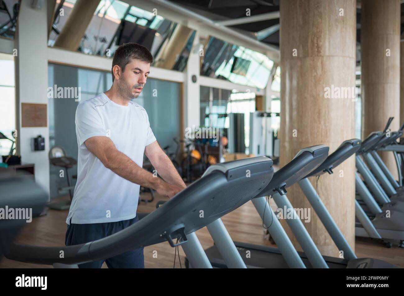 Man jogging on a treadmill during a cardio running warmup exercise in ...