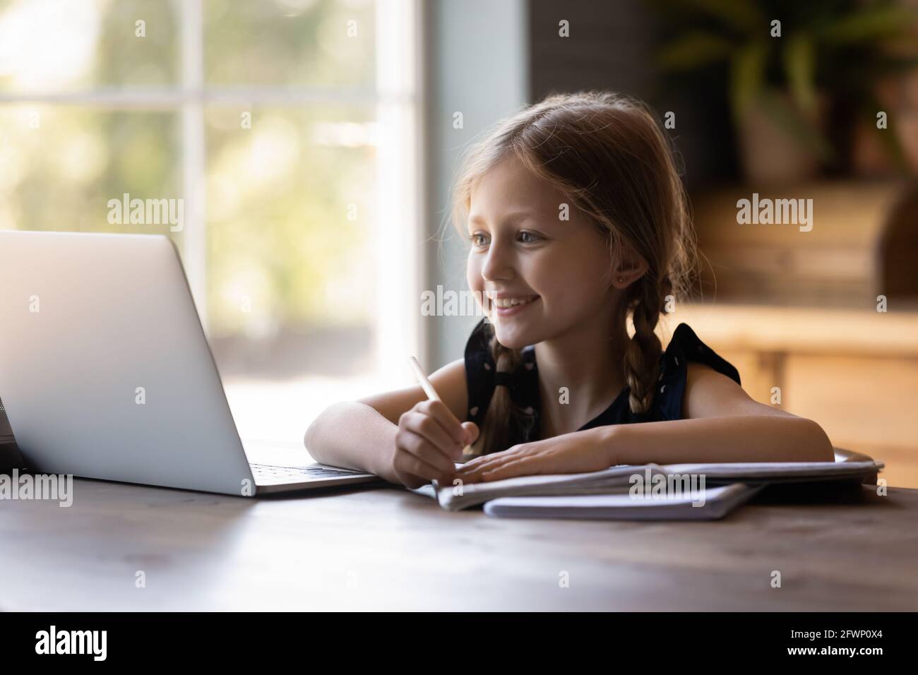 Happy sweet kid studying from home, doing school homework Stock Photo ...