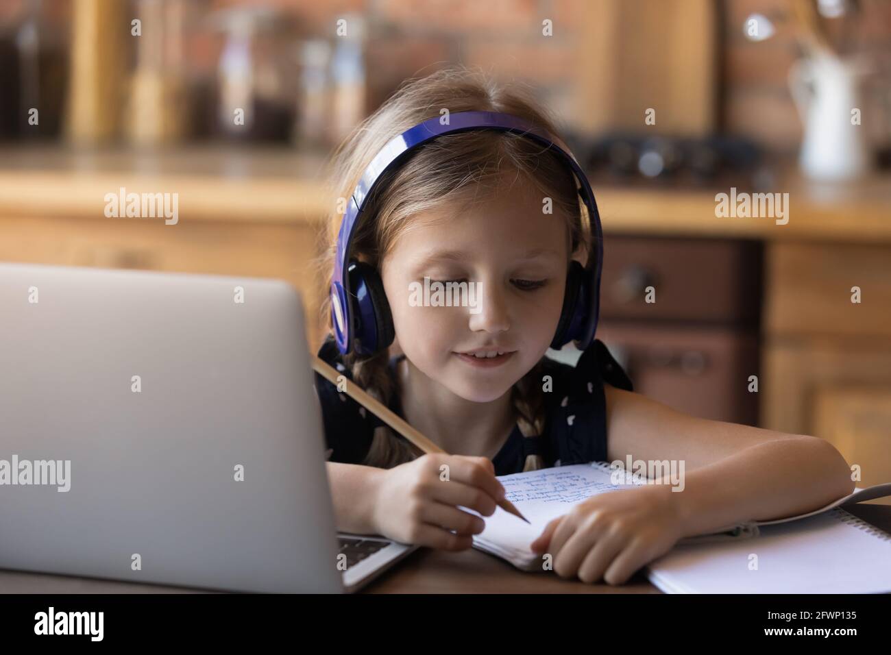 Cute primary schoolkid doing school task at home Stock Photo - Alamy