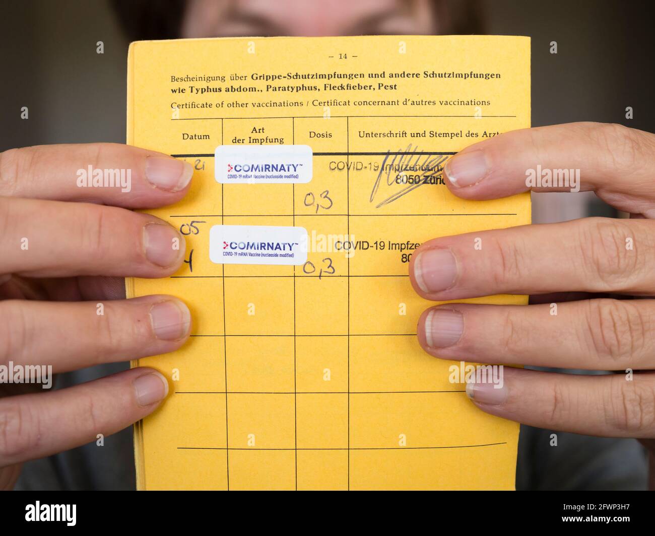 A caucasian woman is holding her International Immunization Certificate ...