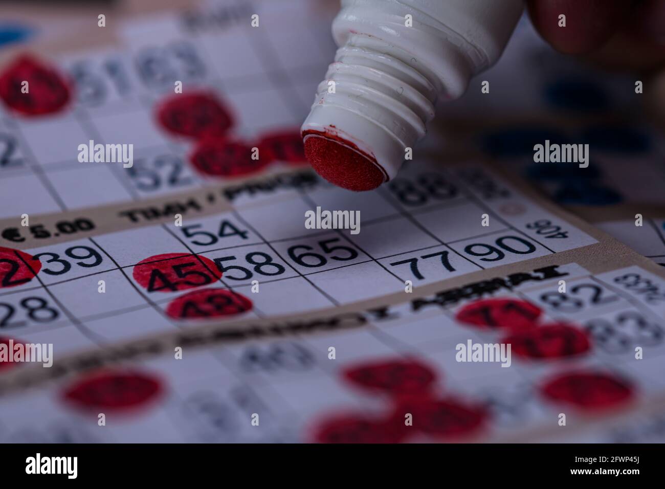 Playing Bingo. Marking numbers with red marker Stock Photo - Alamy